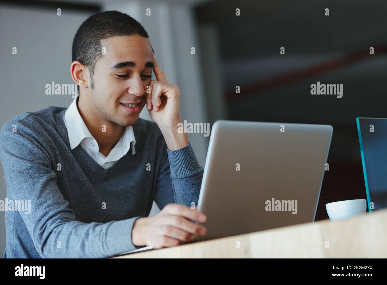 Young man reading or watching media on a laptop computer Stock Photo ...