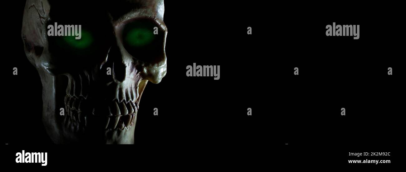 Glowing green eyed skull with copy space on black Stock Photo - Alamy
