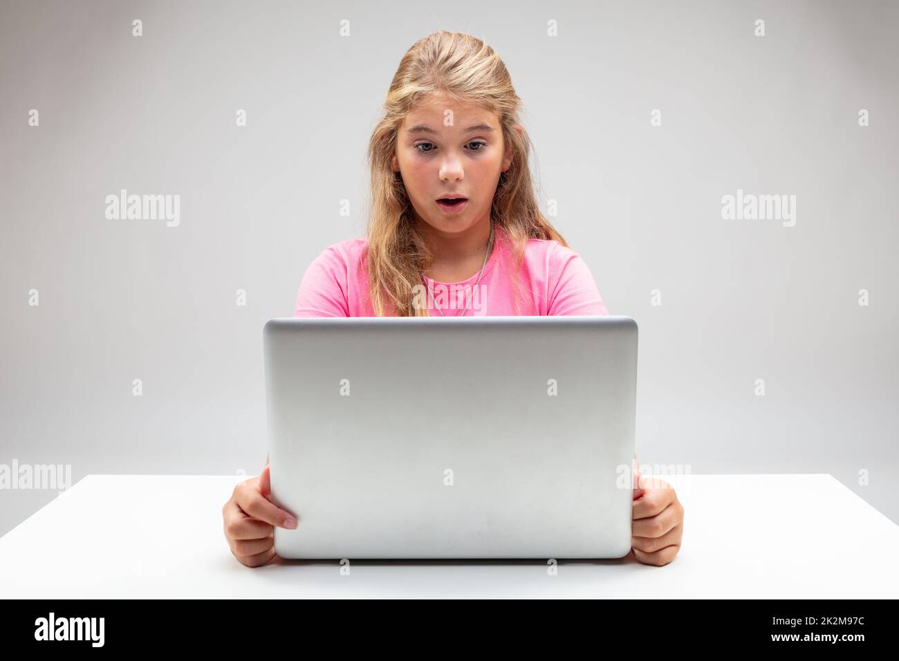 Little girl staring at her laptop in astonishment Stock Photo - Alamy