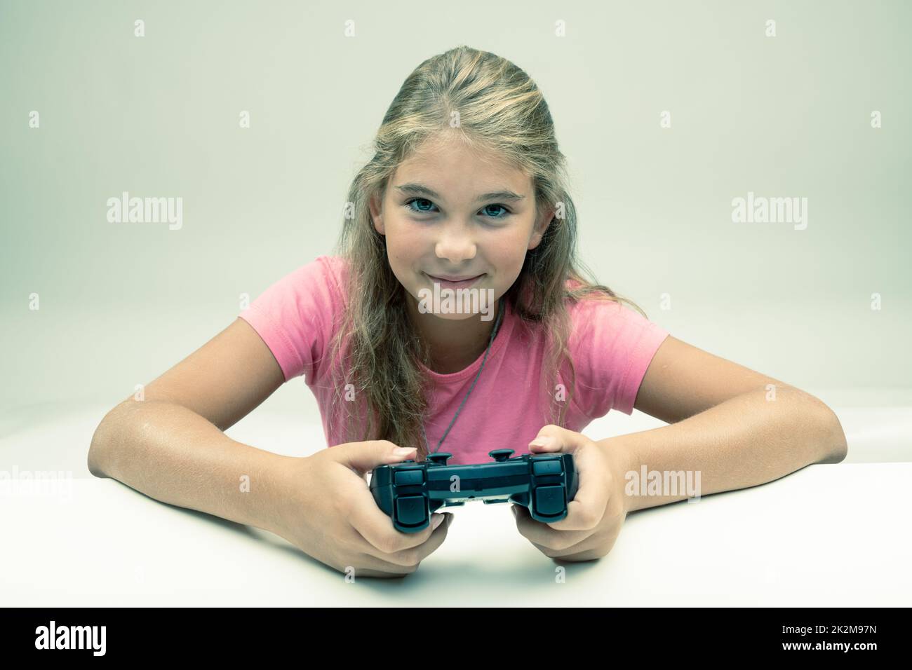 Pretty little girl holding a gaming console Stock Photo - Alamy