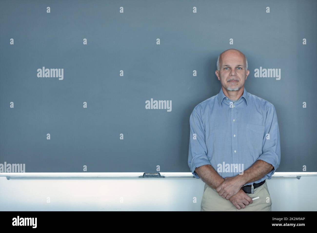 Senior male teacher standing in front of a blank chalkboard Stock Photo ...
