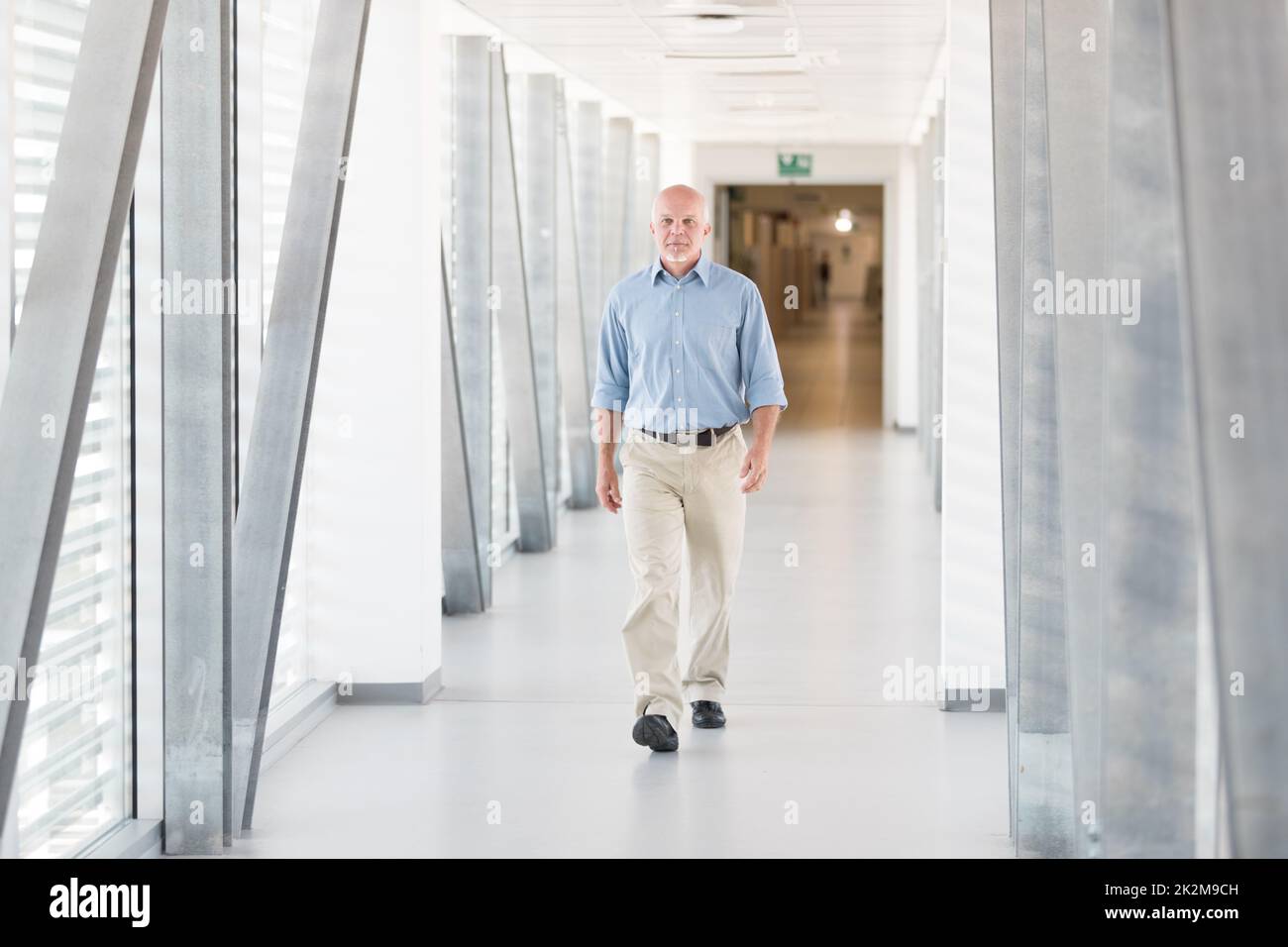 man walking down the hallway inside a new building Stock Photo - Alamy
