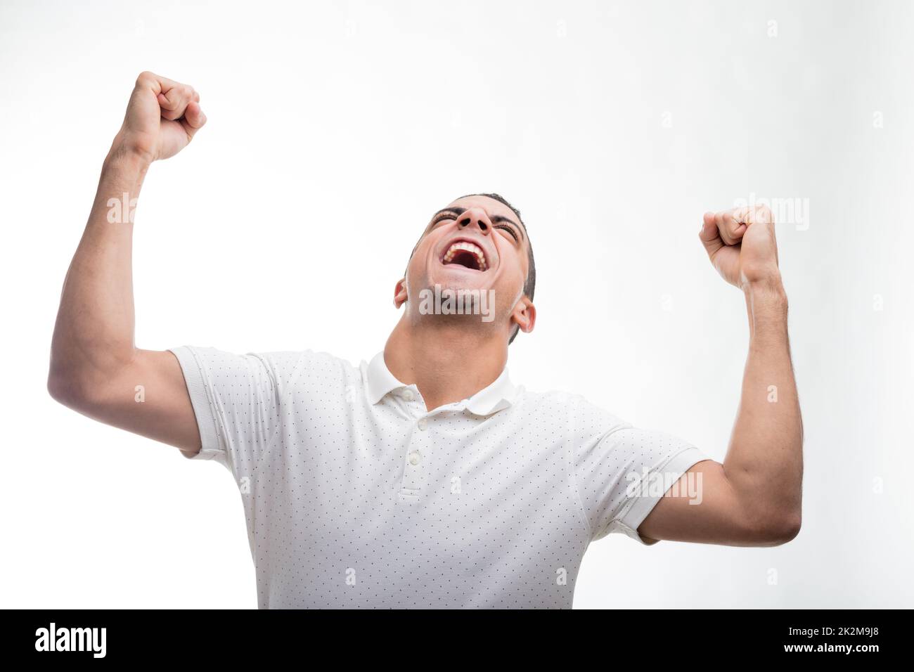 Young man clenching fists in winning gesture Stock Photo - Alamy
