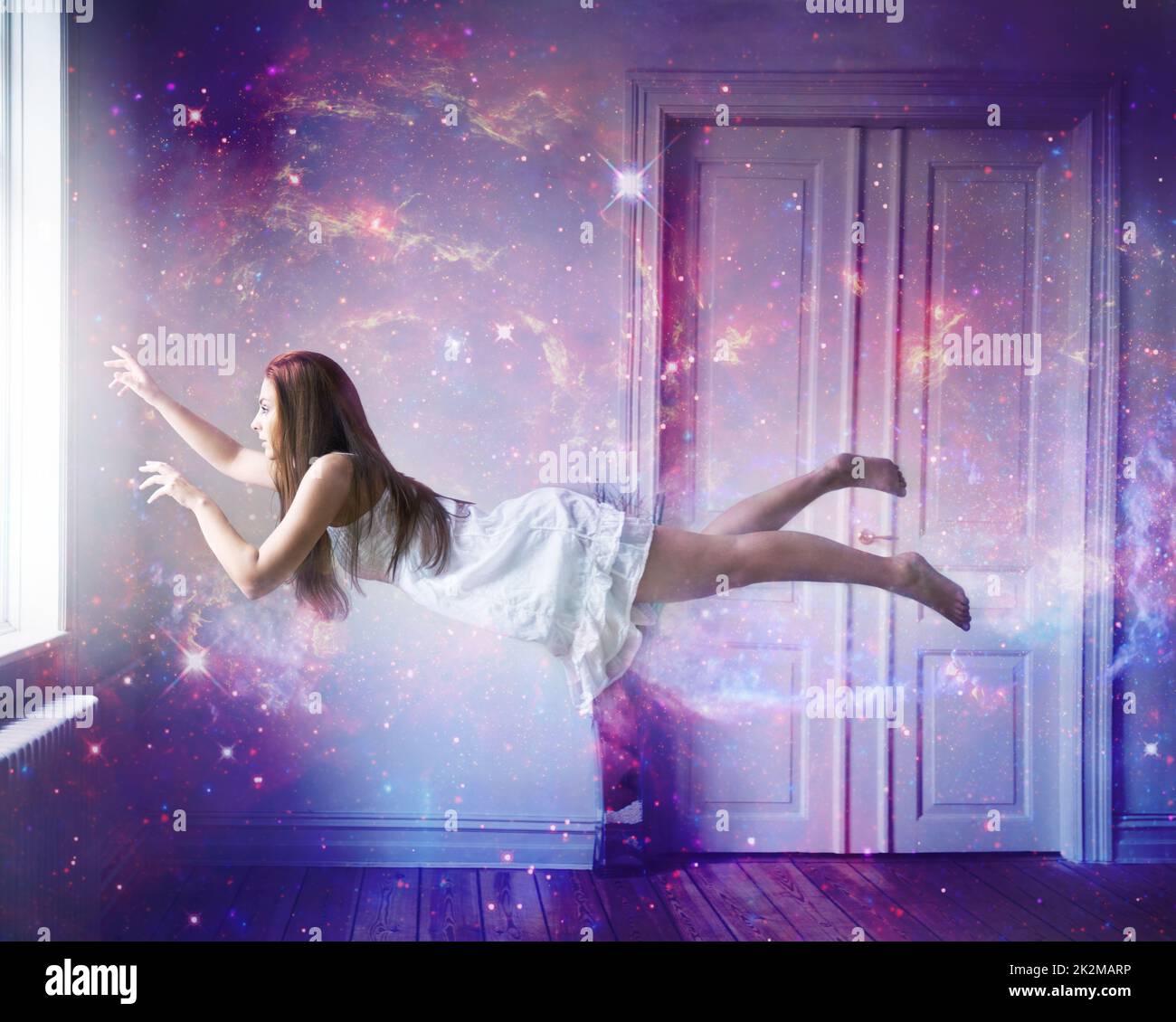 Lost in her dreams. A young woman floating out of a window in a dreamlike state Stock Photo - Alamy