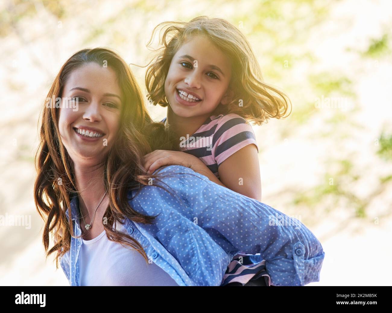 Mother giving daughter a piggyback hi-res stock photography and images ...