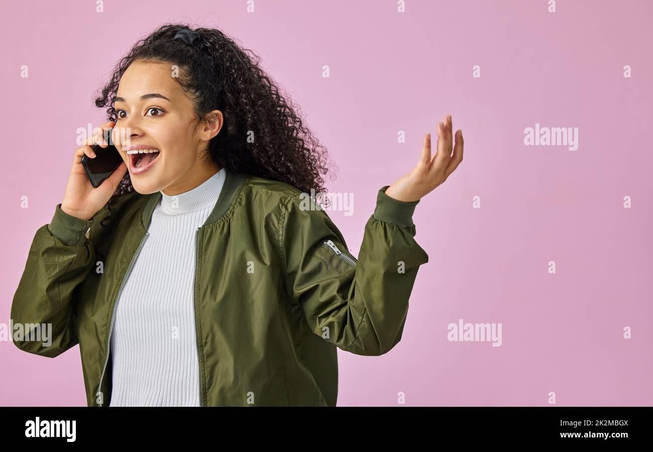 Wait, what. Shot of an attractive young woman standing against a pink ...