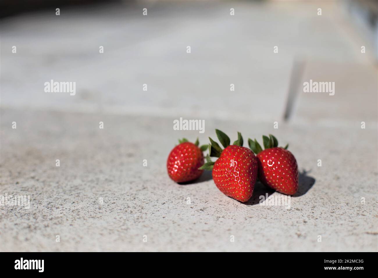 strawberries laying on stone ground Stock Photo - Alamy