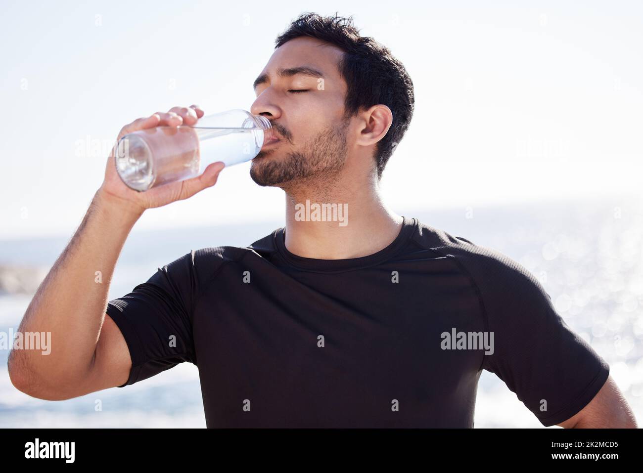 Stay hydrated. Cropped shot of a handsome young male athlete hydrating ...