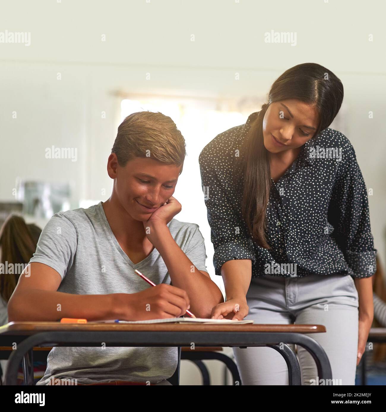 Showing him how its done. Shot of a young teacher explaining something ...