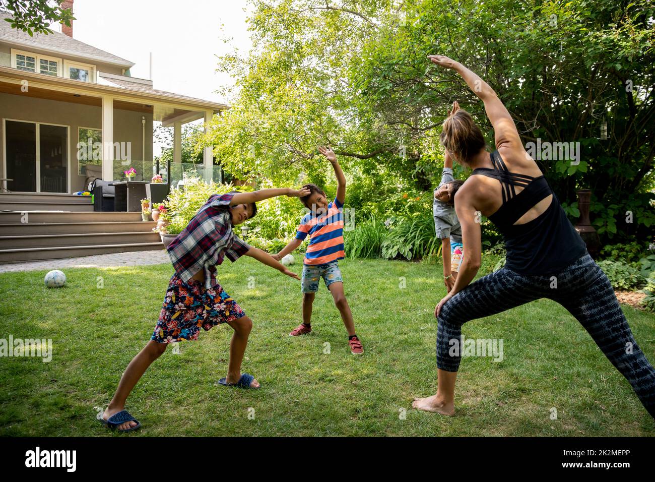 Mother and children practising yoga in backyard Stock Photo - Alamy
