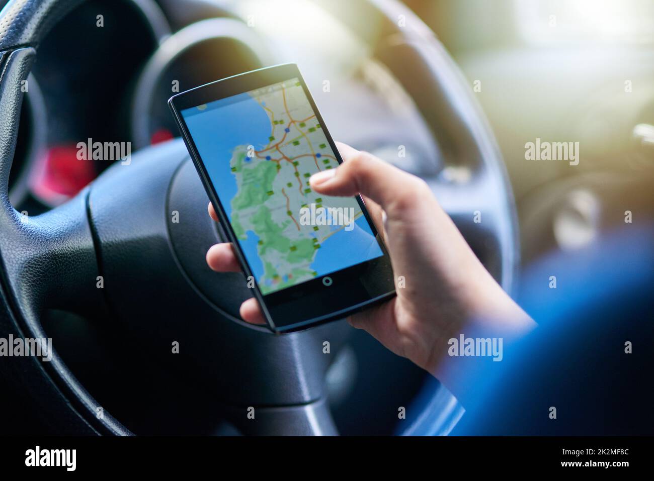 Checking for the quickest route. Shot of a person in a car using their ...