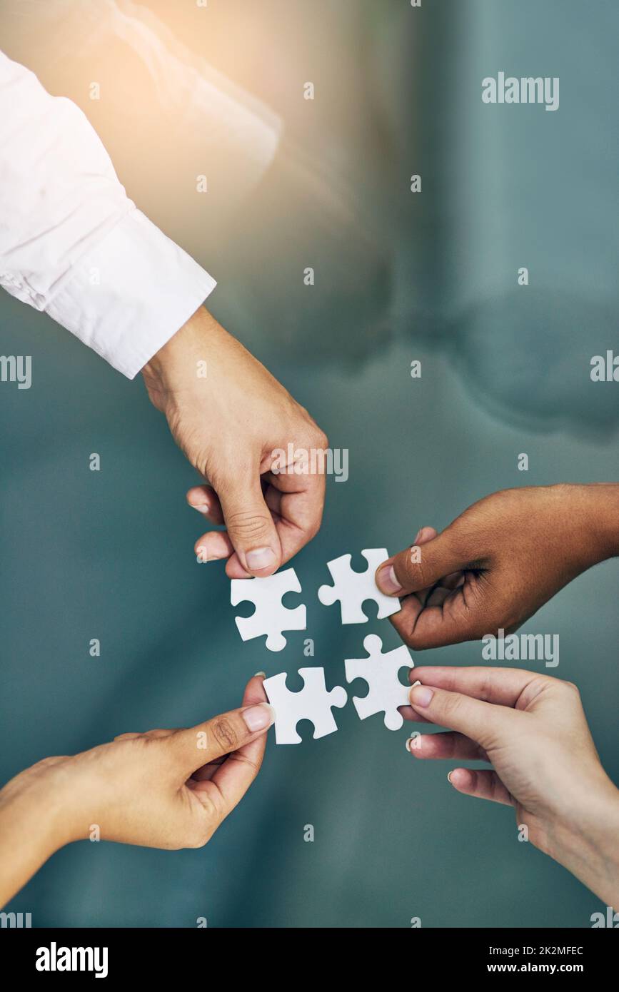 We fit together as a team. Shot of hands putting puzzle pieces together ...
