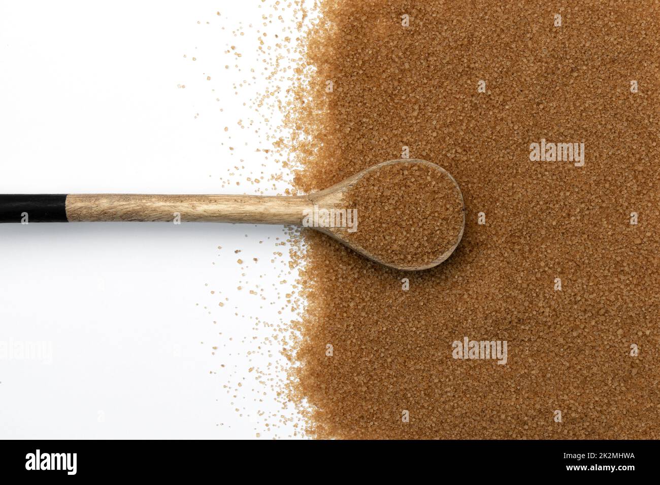 large spoon with brown sugar on white background, frame of unrefined ...