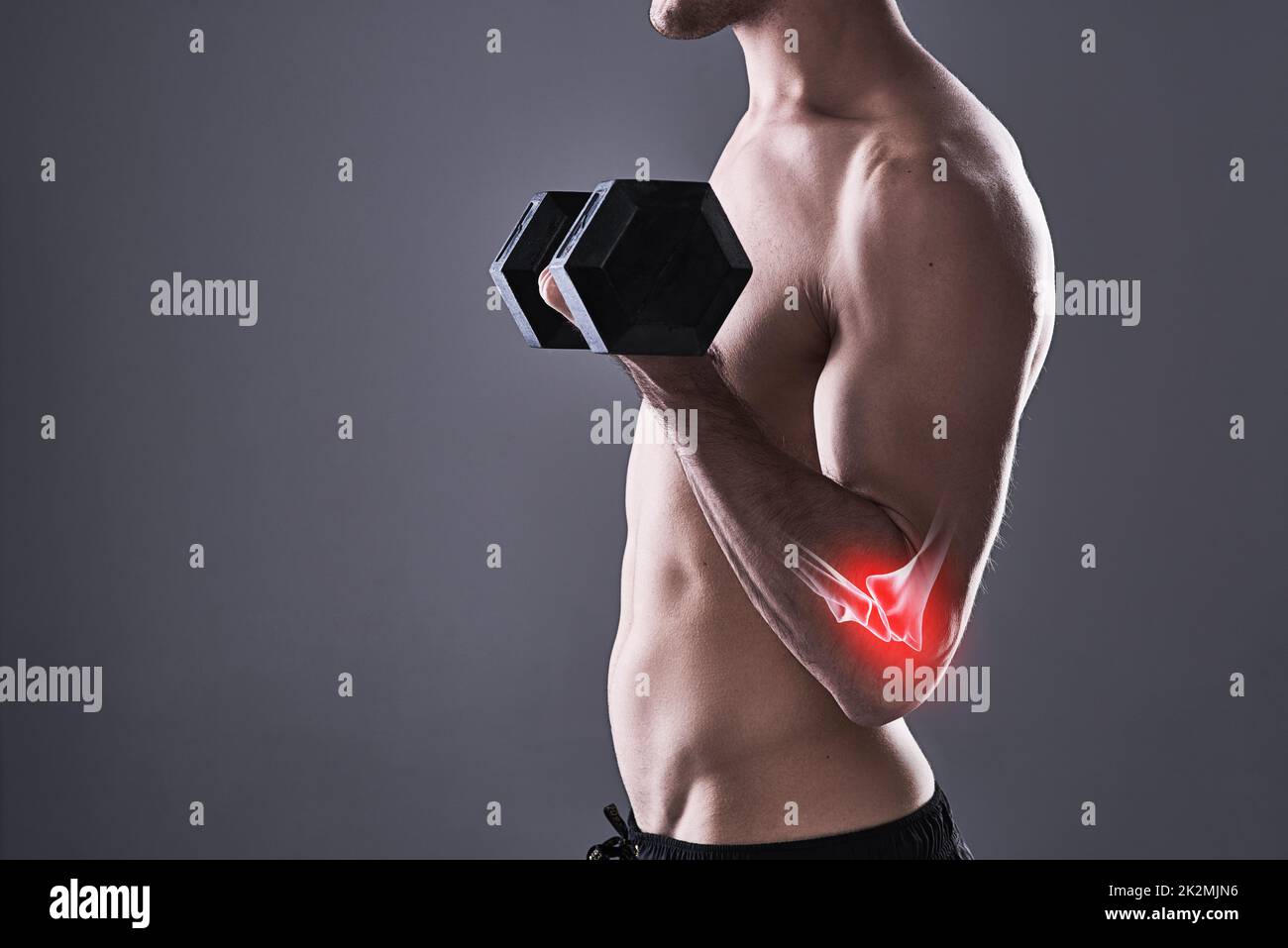 Lifting through the pain. Cropped shot of a young man in the studio ...