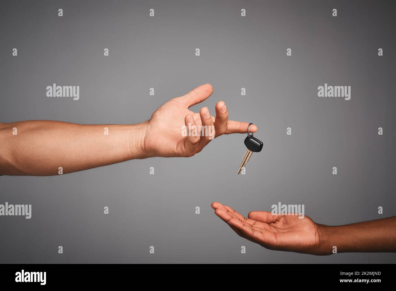 Handing over keys to the designated driver. Studio shot of ...