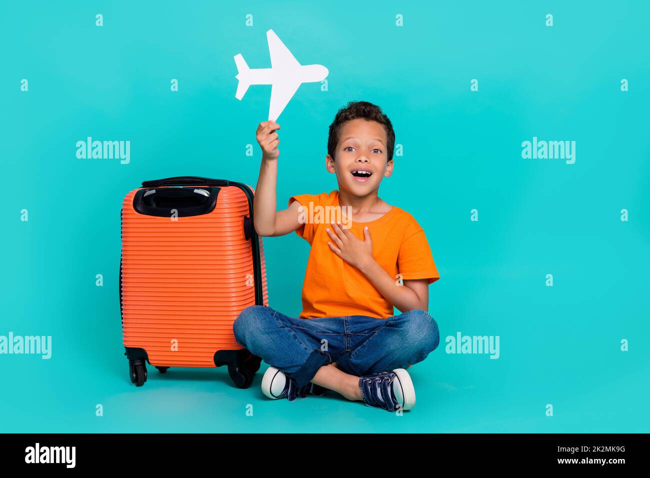 Photo of cute boy sit arm point himself hand hold paper plane dream fly ...