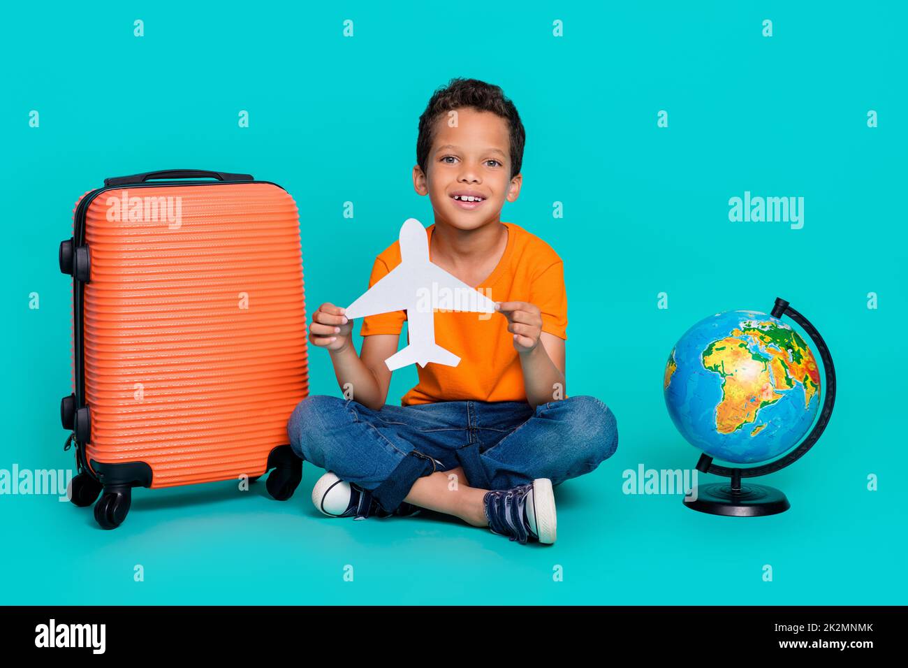 Photo of cute boy touristsit sit hand hold paper aircraft airplane ...