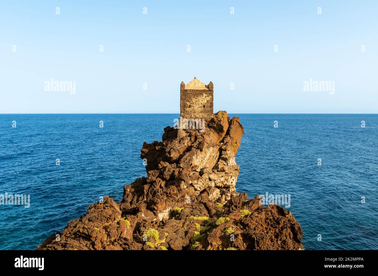 A medieval watchtower perched high on an outcrop of volcanic lava ...