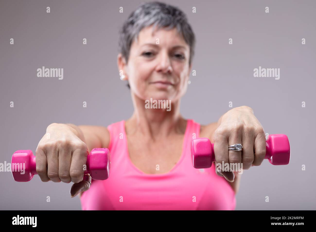 Older woman working out with a pair of dumbbells Stock Photo - Alamy