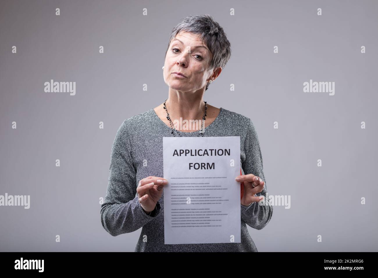 Expectant woman holding up an application form Stock Photo - Alamy