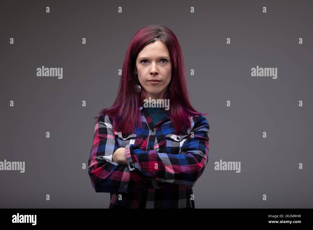 Serious determined young woman with folded arms Stock Photo - Alamy