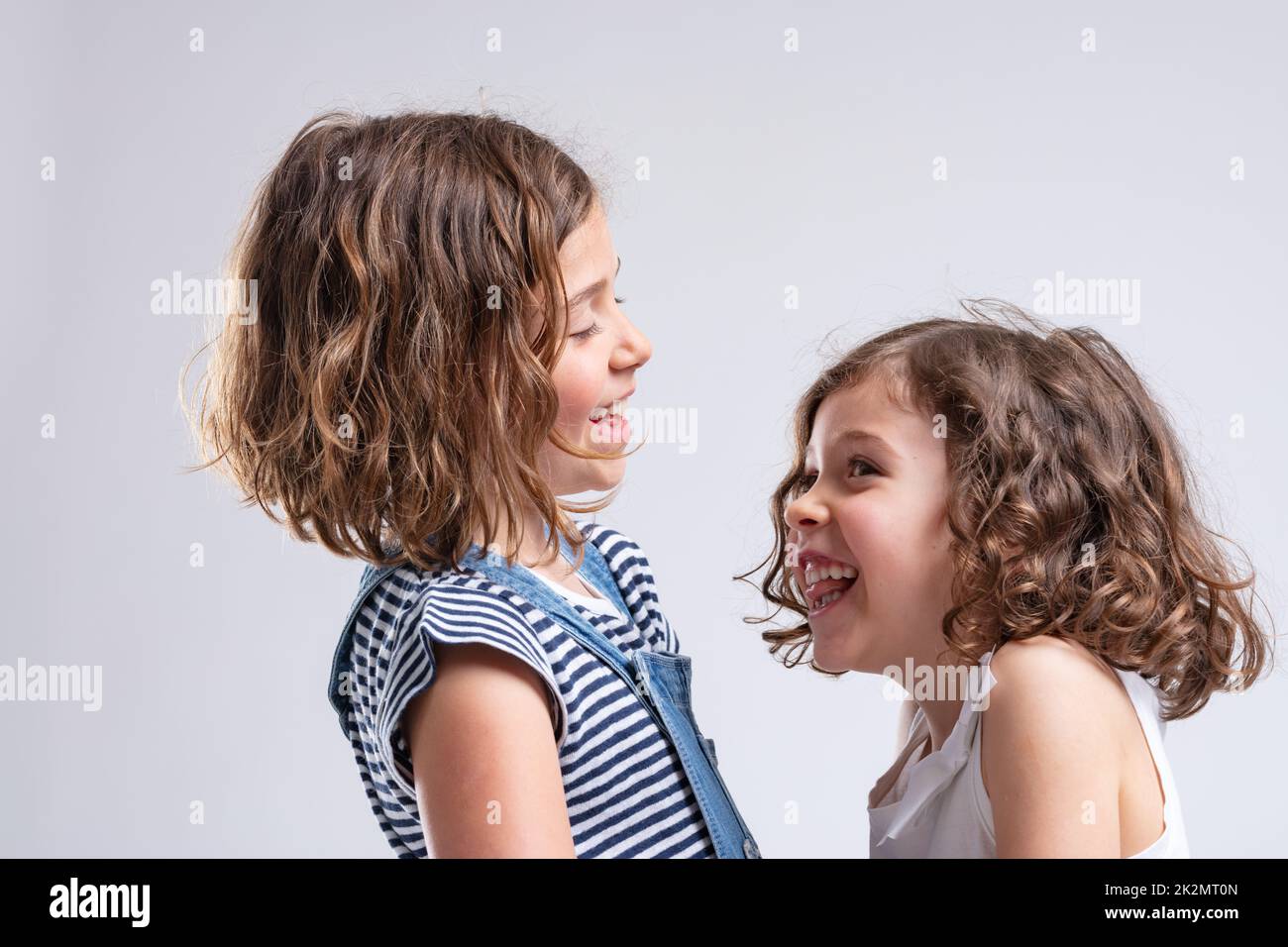 Two cheerful little sisters laughing together Stock Photo - Alamy