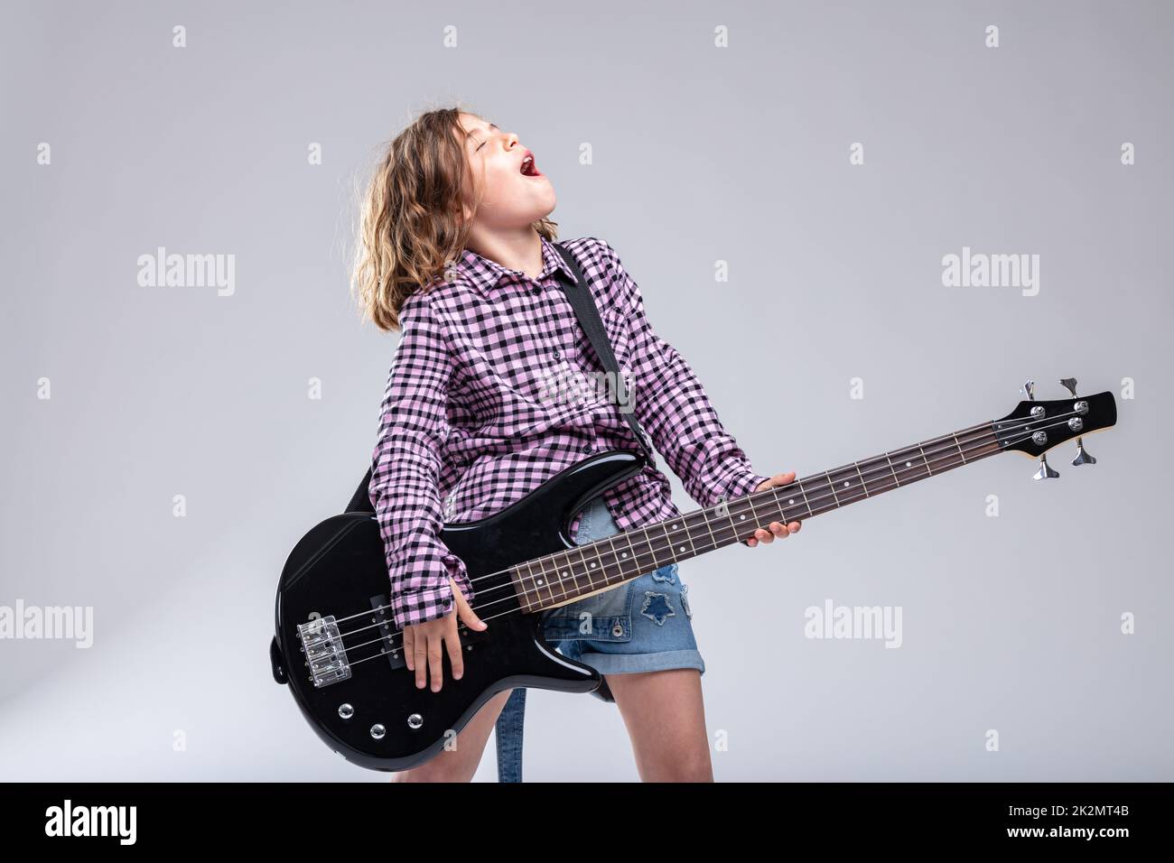 Talented young girl guitarist singing a lyric Stock Photo - Alamy