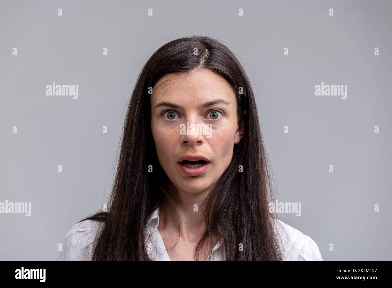 Portrait of young long-haired astonished woman Stock Photo - Alamy