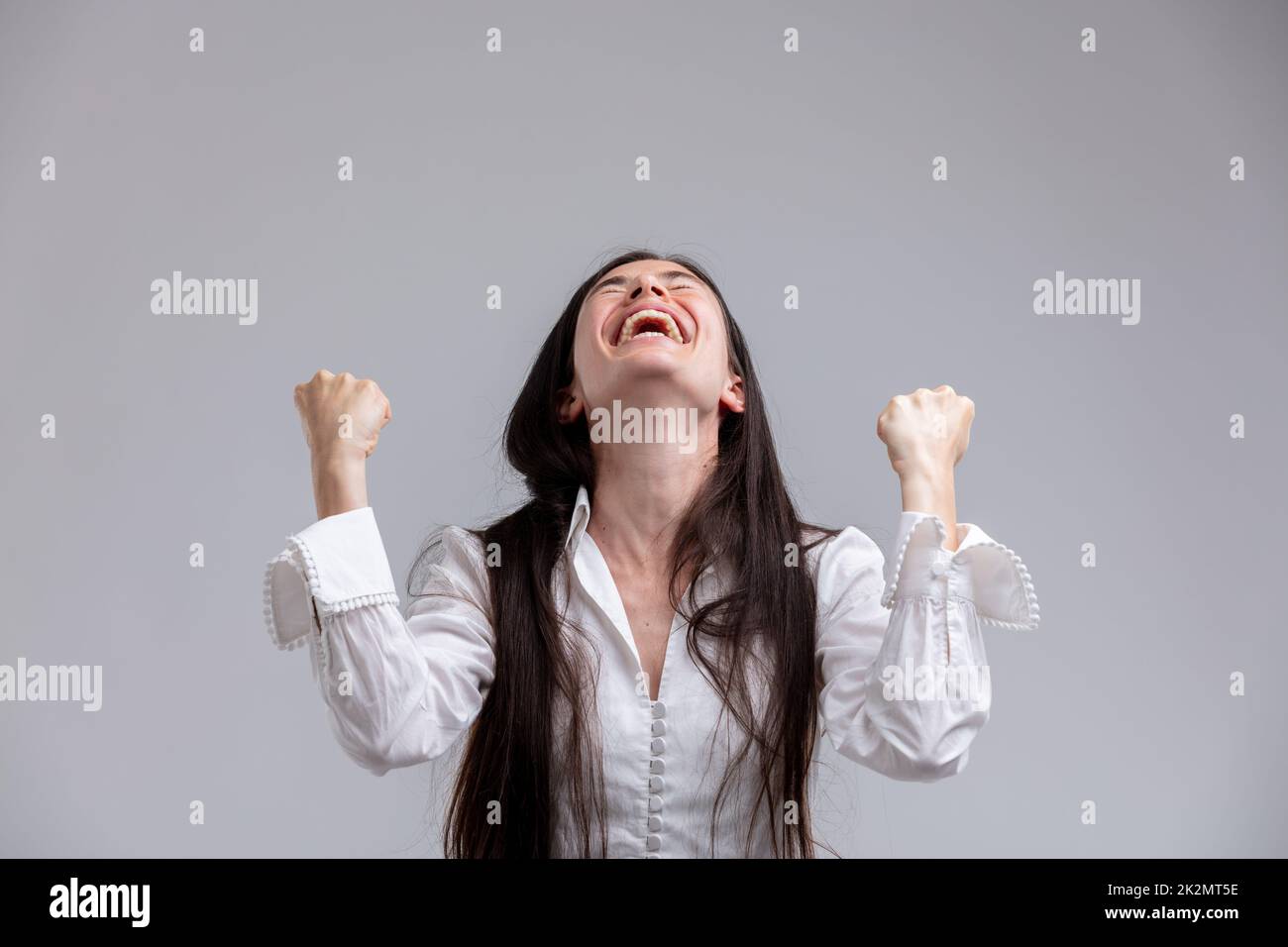 Jubilant woman laughing and clenching her fists Stock Photo - Alamy