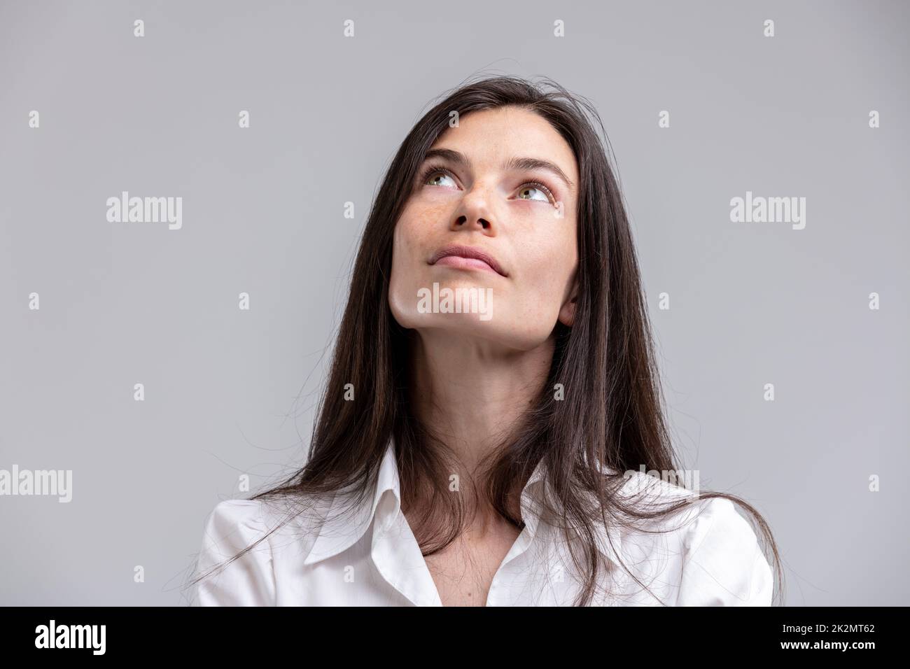 Thoughtful attractive woman looking up Stock Photo - Alamy