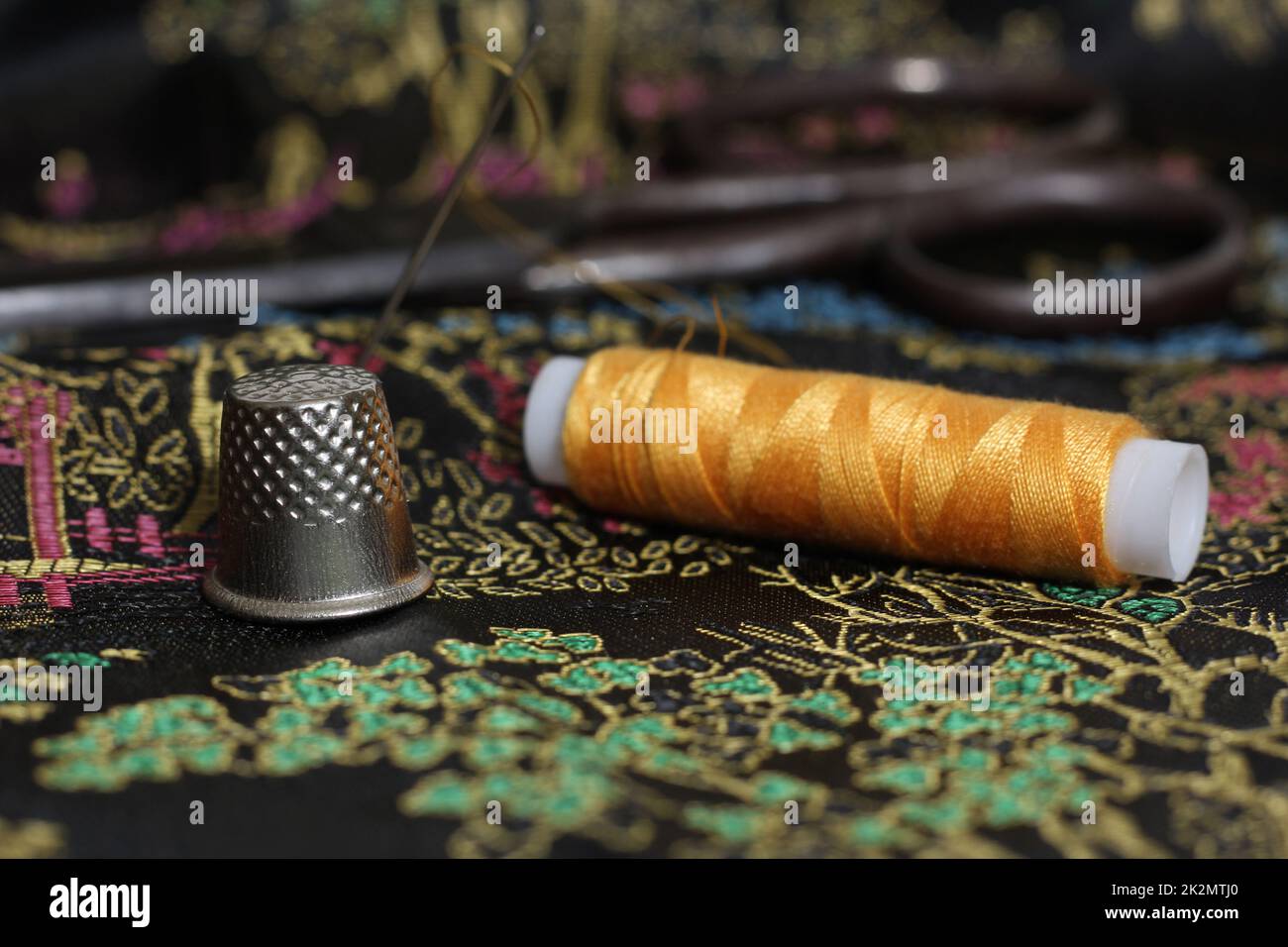 Yellow Thread and Thimble on Vintage Chinese Black Silk Stock Photo - Alamy