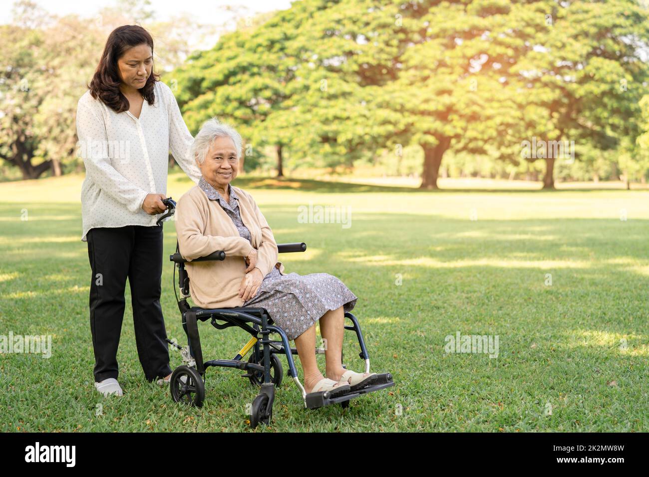 Caregiver help and care Asian senior or elderly old lady woman patient ...