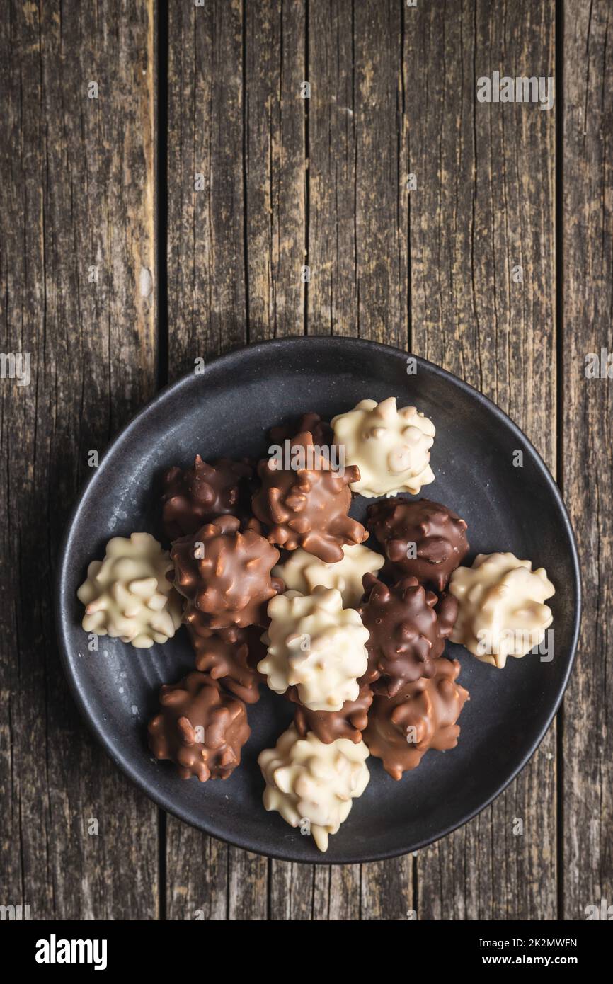 Chocolate truffles. Sweer pralines on plate on wooden table Stock Photo ...