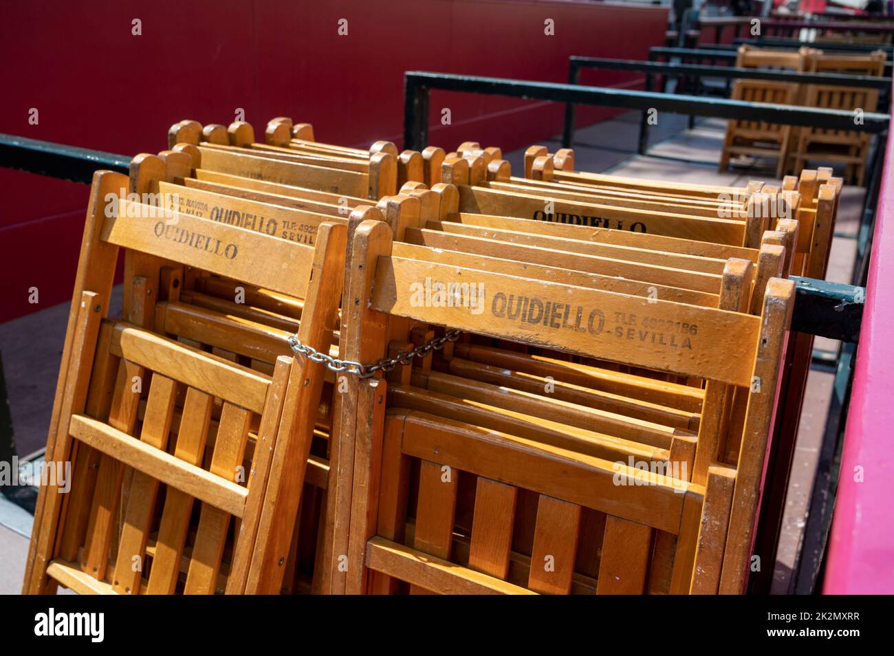 Wooden chairs stacked up and chained together on a street in Cadiz ...
