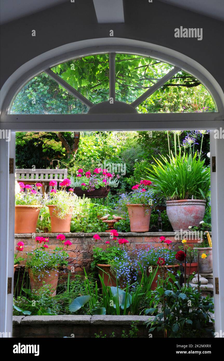 Portrait of a garden view through open double doors Stock Photo - Alamy