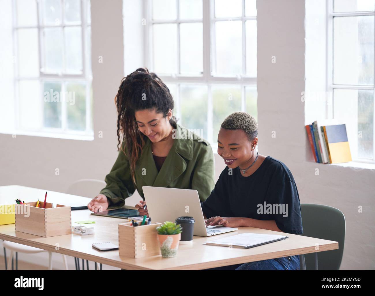 College students working together two young women friends brainstorming ...