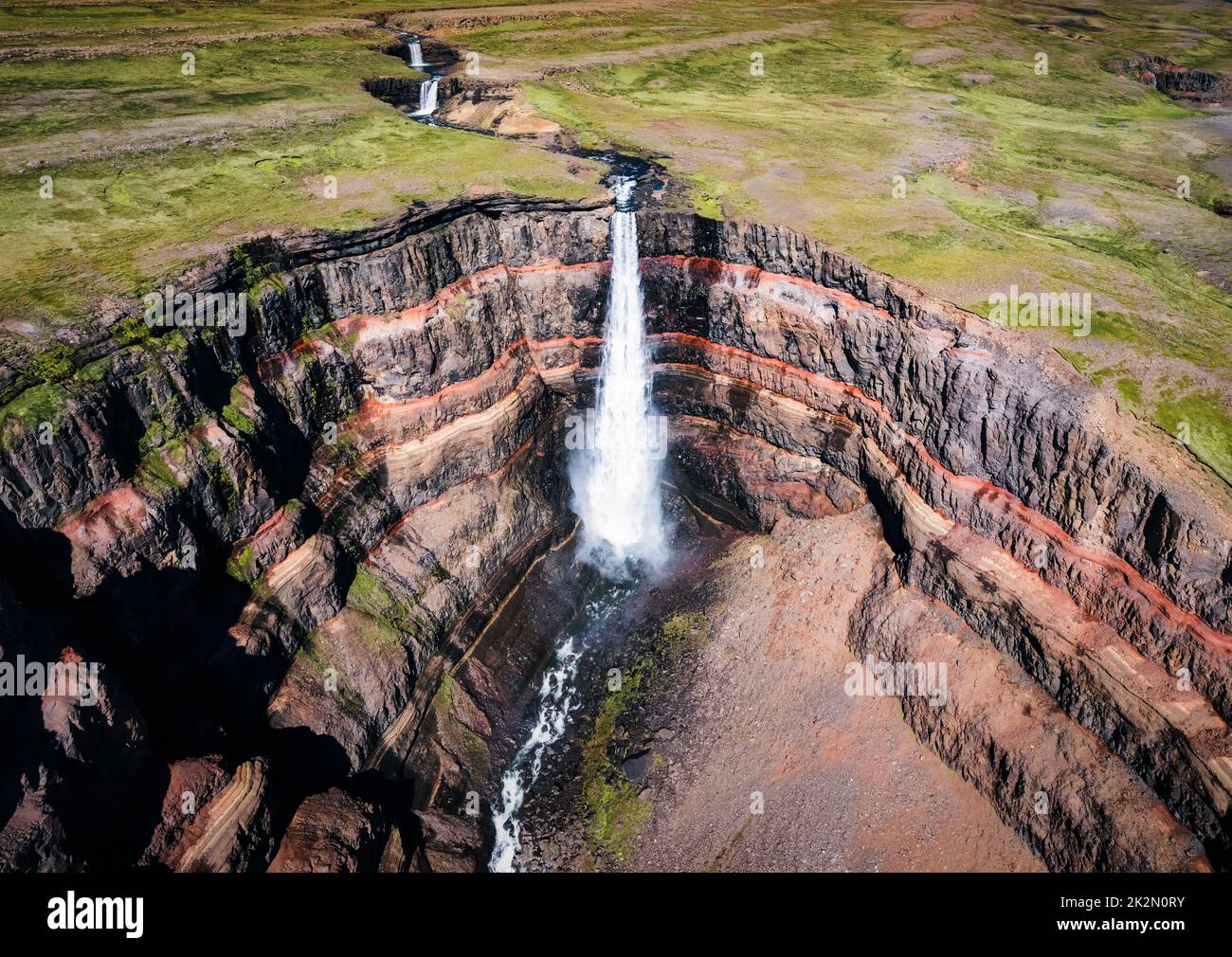 Aerial view of Hengifoss waterfall surrounded by layers of basaltic ...