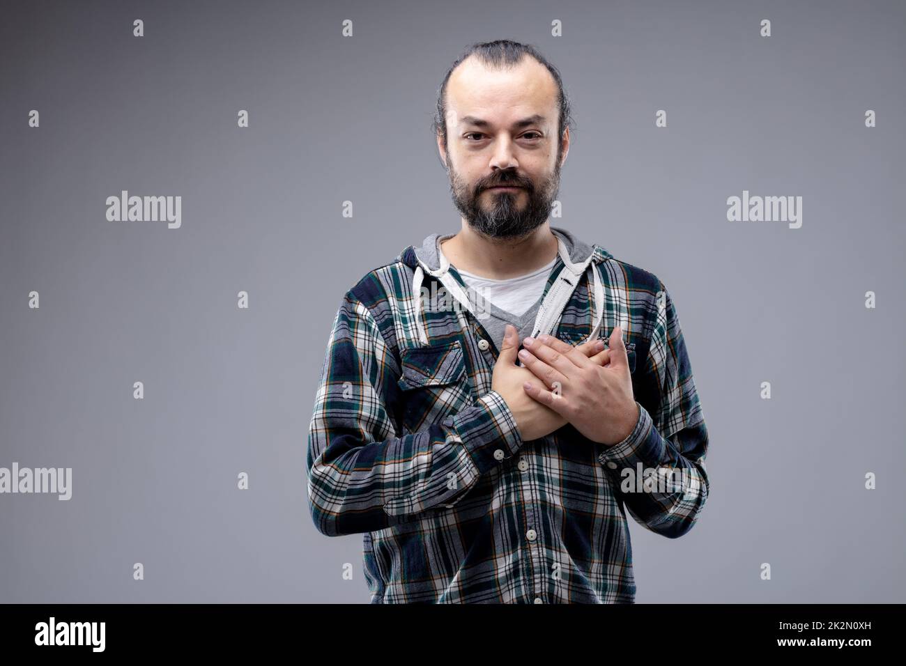 Sincere man crossing his hands over his heart Stock Photo - Alamy