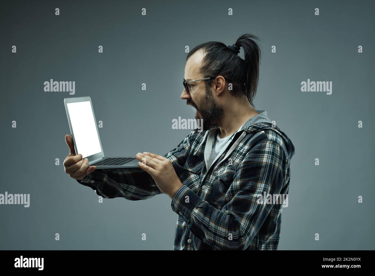Man gawping at his laptop with an aghast expression Stock Photo - Alamy