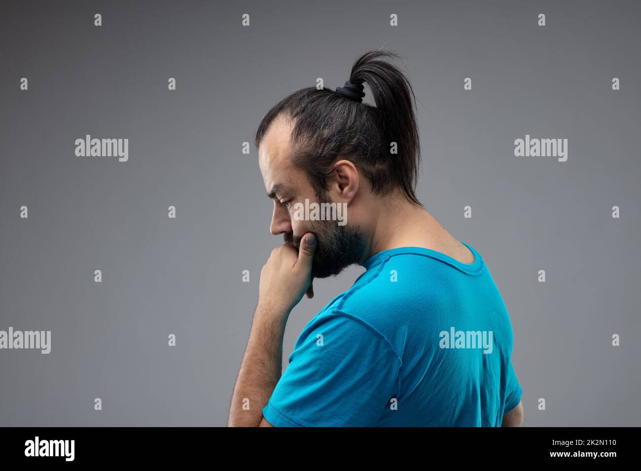 A man with ponytail, guessing gesture Stock Photo - Alamy