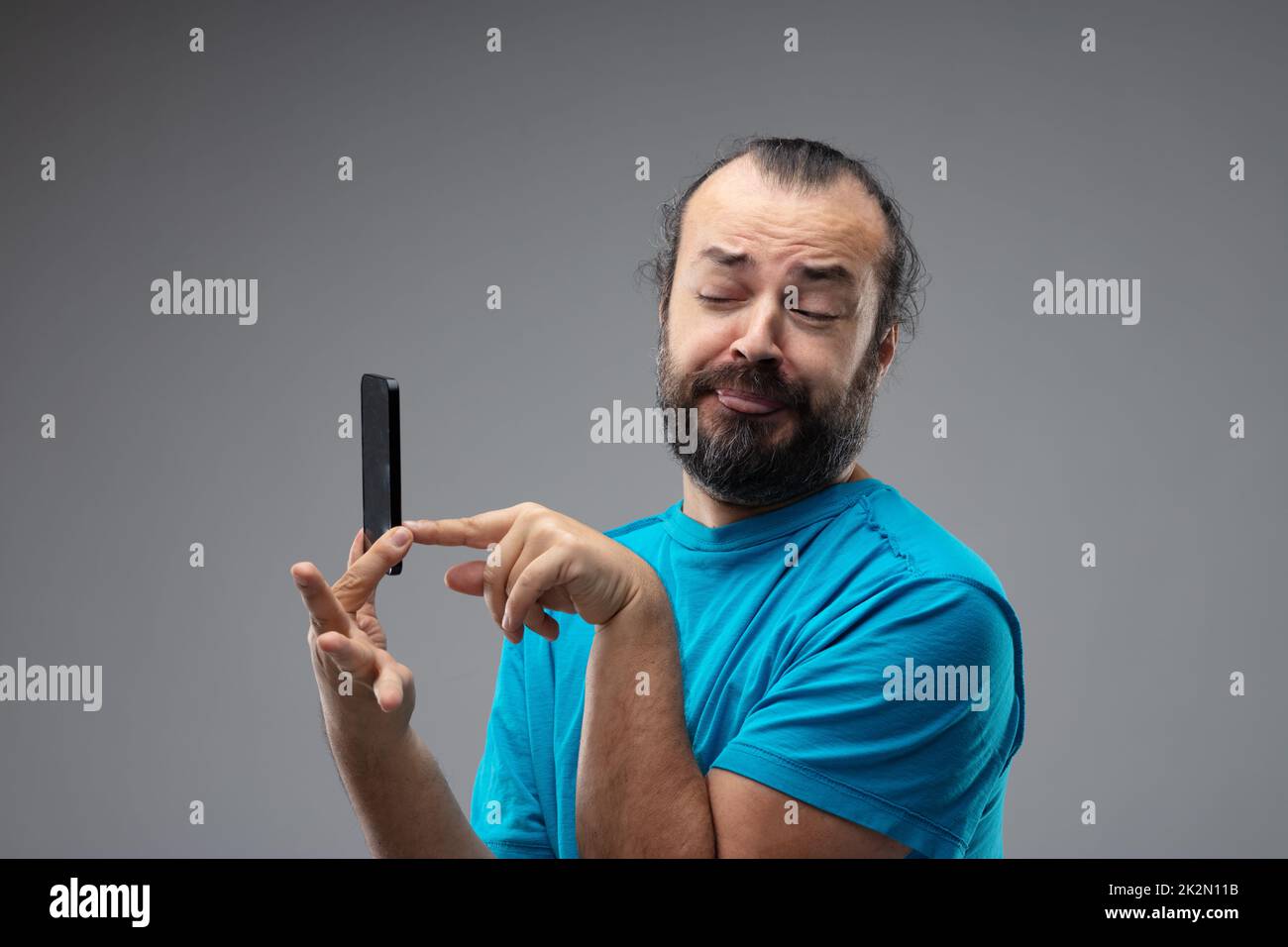 Man squeamishly poking phone screen Stock Photo - Alamy