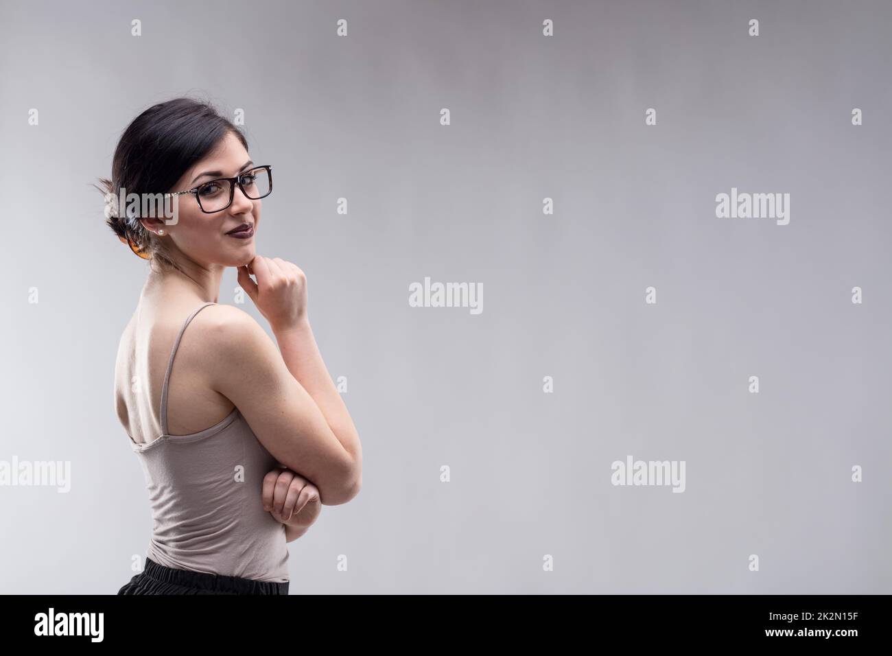 Beautiful woman looking over shoulder Stock Photo - Alamy
