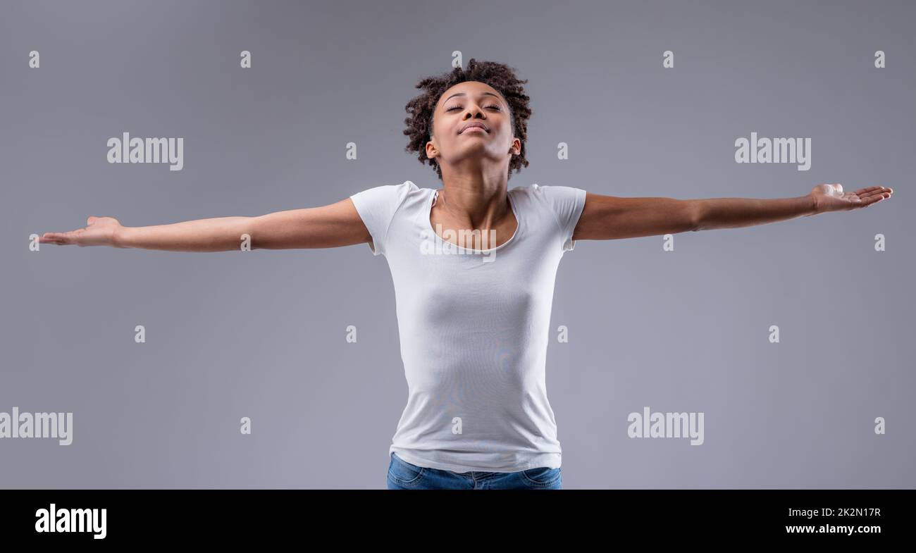 Blissful young woman relaxing with outstretched arms and smile Stock ...