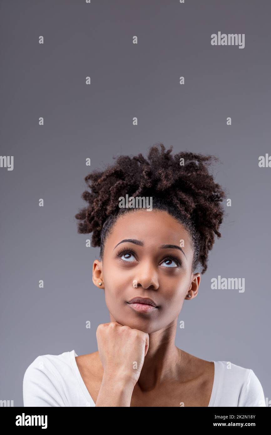 Thoughtful young Black woman with hand to chin Stock Photo - Alamy