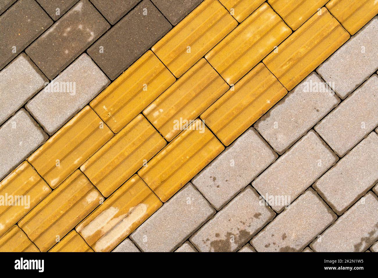 Sidewalk with yellow tactile paving Stock Photo - Alamy