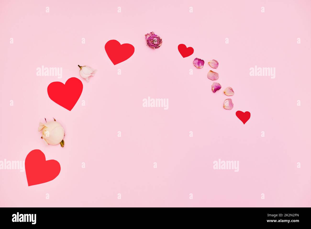 red paper hearts and rose petals on pink background Stock Photo - Alamy
