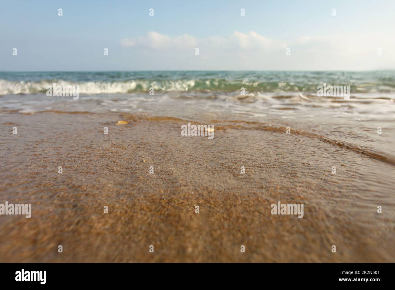 Wet sand on the beach, sea in distance, low angle photo on ground level ...