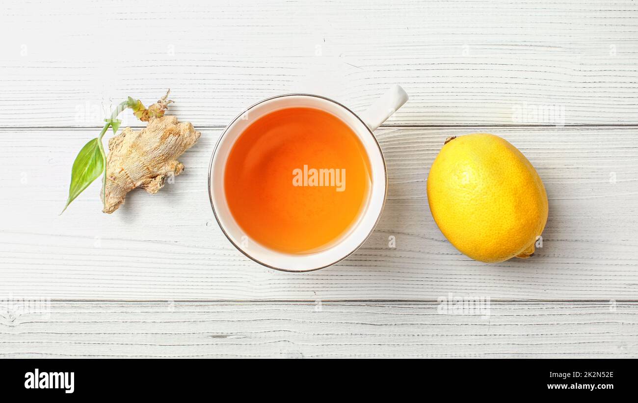 Table top view, cup of freshly brewed tea, lemon, and dry ginger root ...
