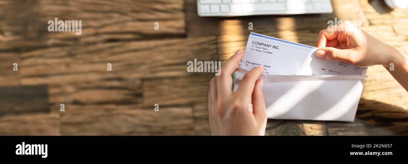 Businessperson Opening Envelope With Paycheck Stock Photo - Alamy
