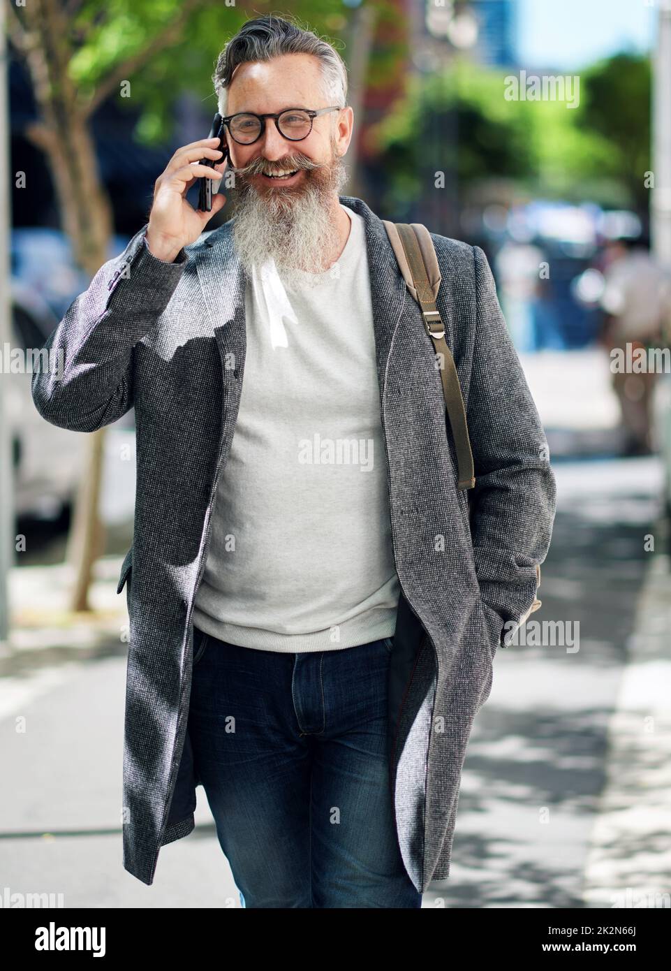 stylish businessman using smartphone having phone call walking in city ...